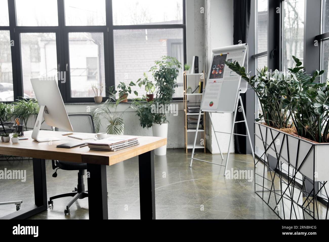 contemporary office, flip chart, work desk, computer monitor, notebooks ...