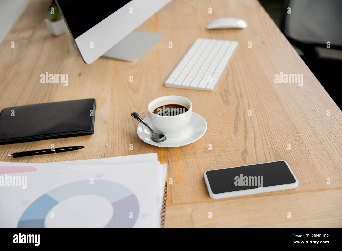 computer monitor, keyboard, coffee cup, notebook, pen, documents with ...
