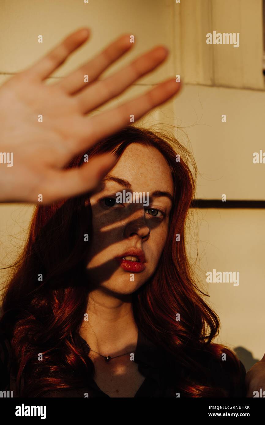 Ginger Girl with Freckles at Sunset Rising Hand to Hide From Sun Stock ...