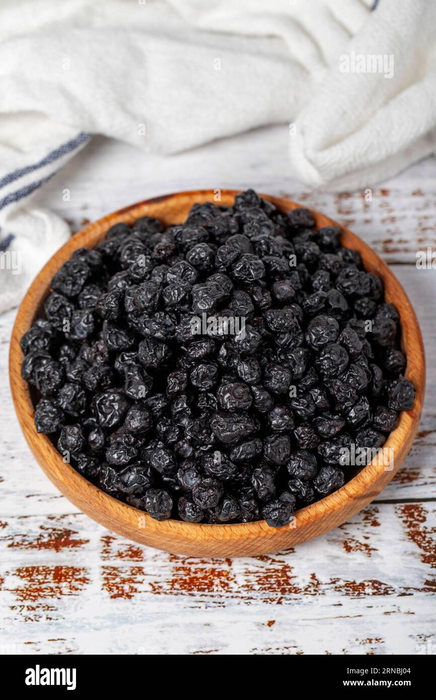 Natural dried blueberry grains in bowl on wooden background. Fruit ...