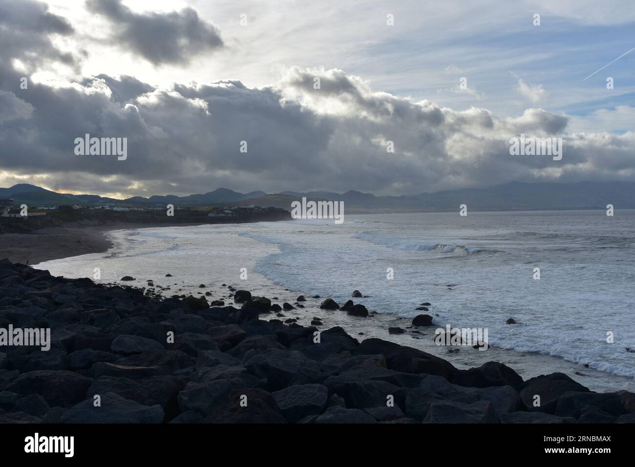 Sun dipping behind the clouds at dusk in Ribeira Grande Stock Photo - Alamy