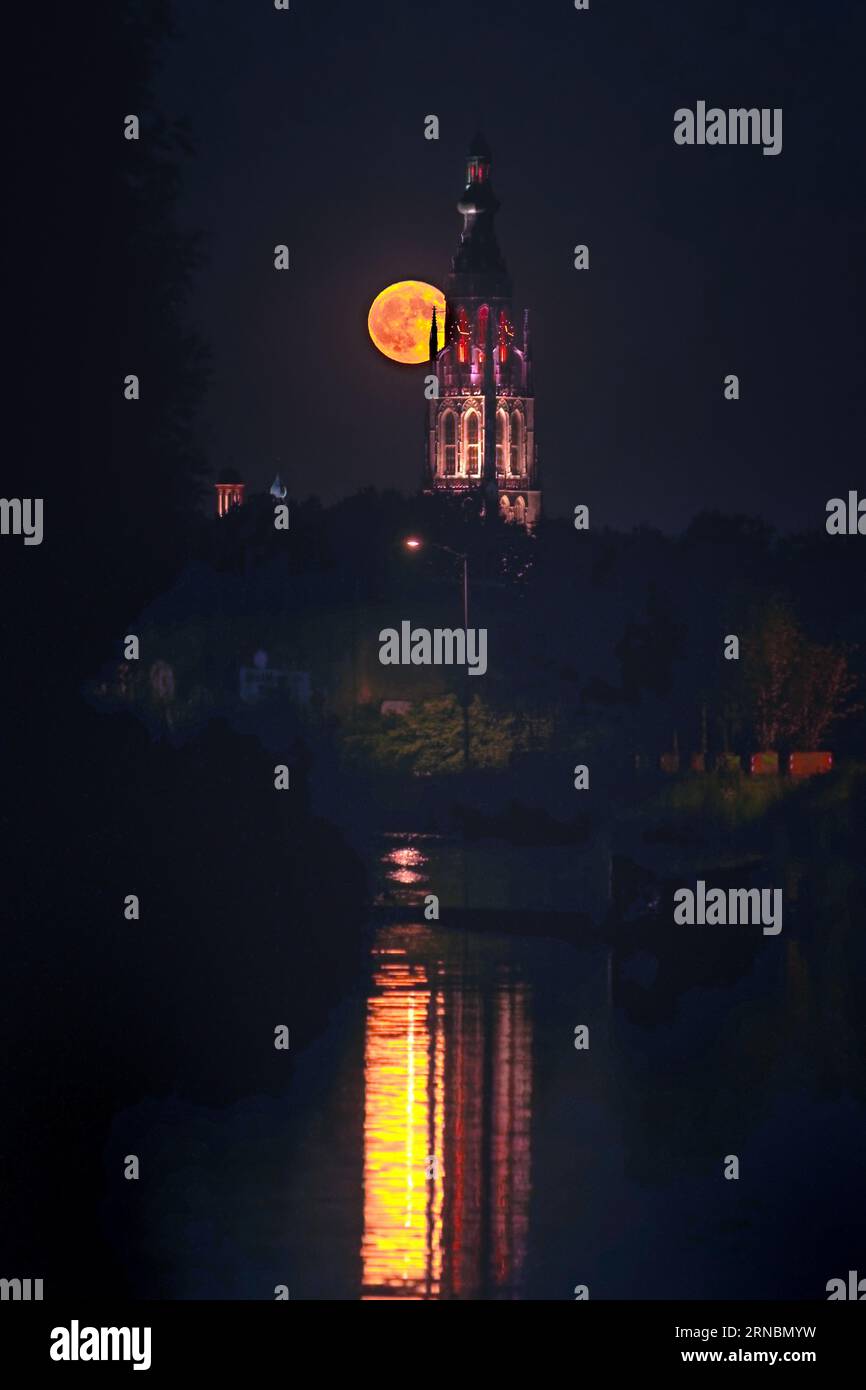 Full moon at religious Breda tower cathedral Stock Photo - Alamy