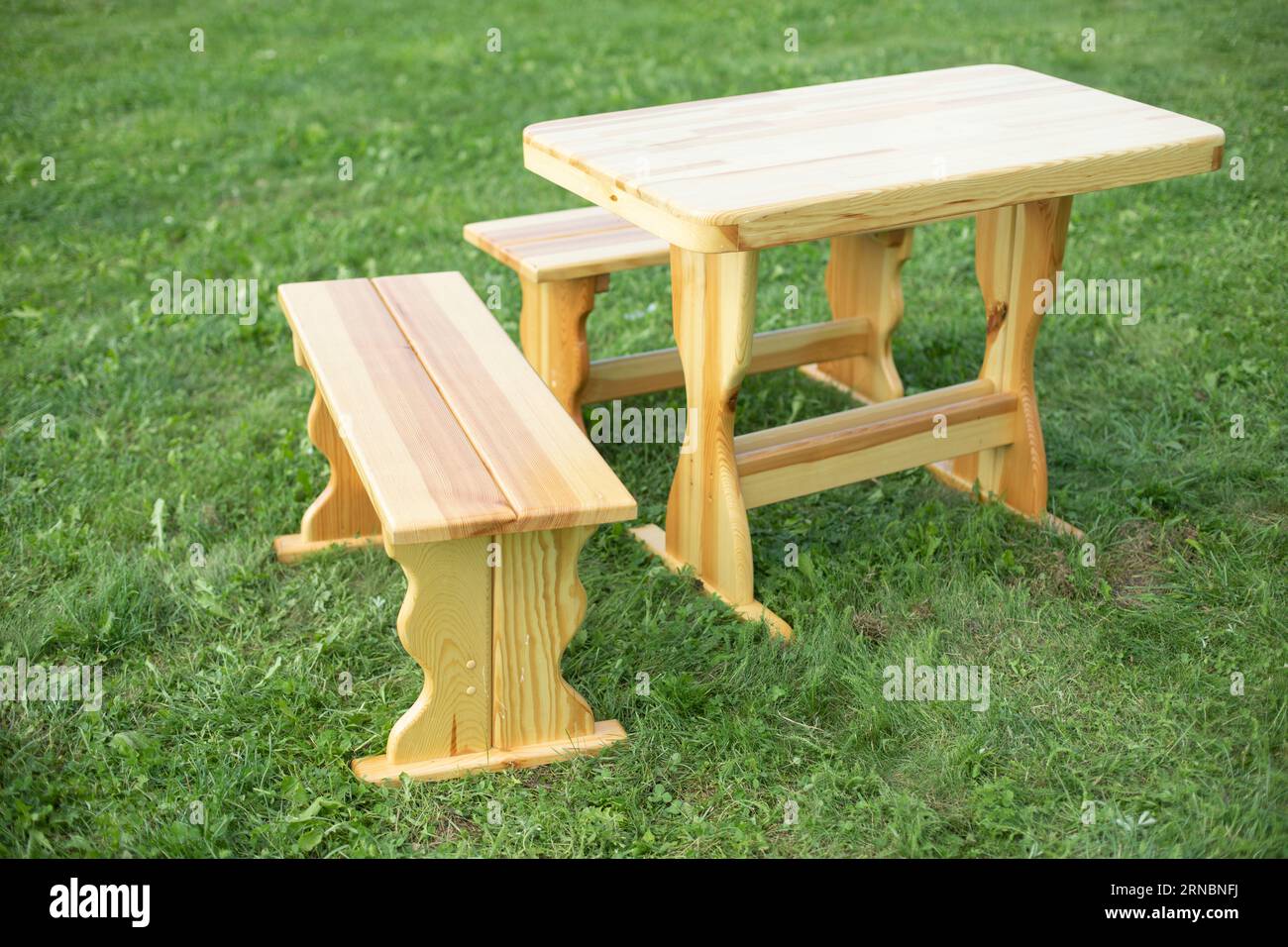 Table made of wood on green grass. Bench and table. Empty picnic area ...