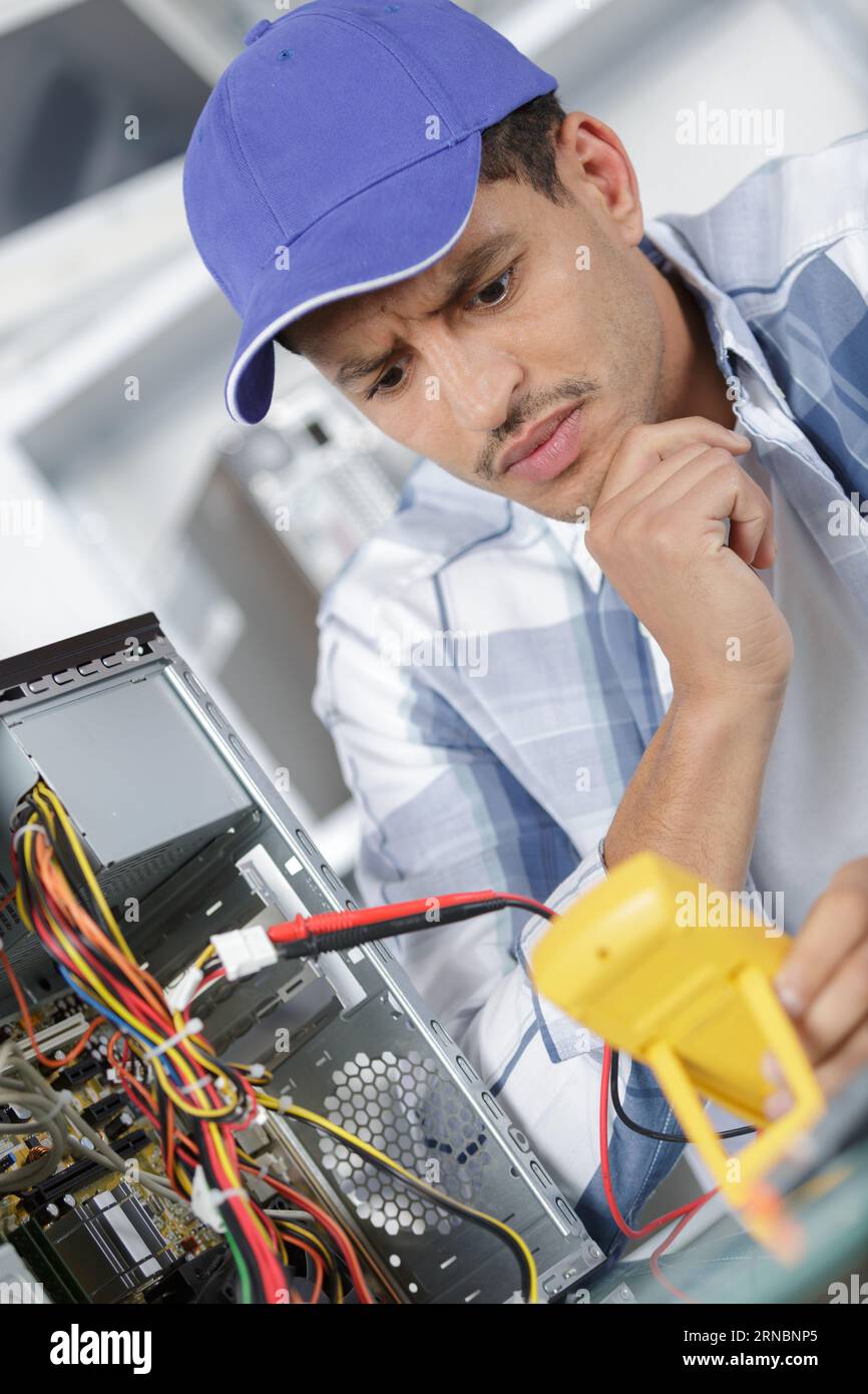 confused computer technician using multimeter Stock Photo - Alamy