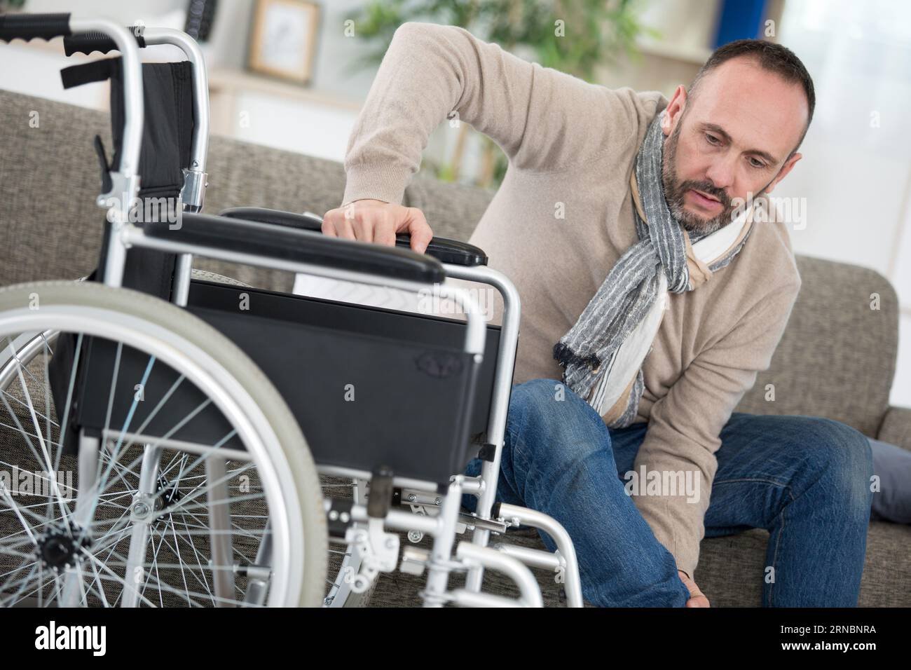 disabled man trying to sit on wheelchair Stock Photo - Alamy