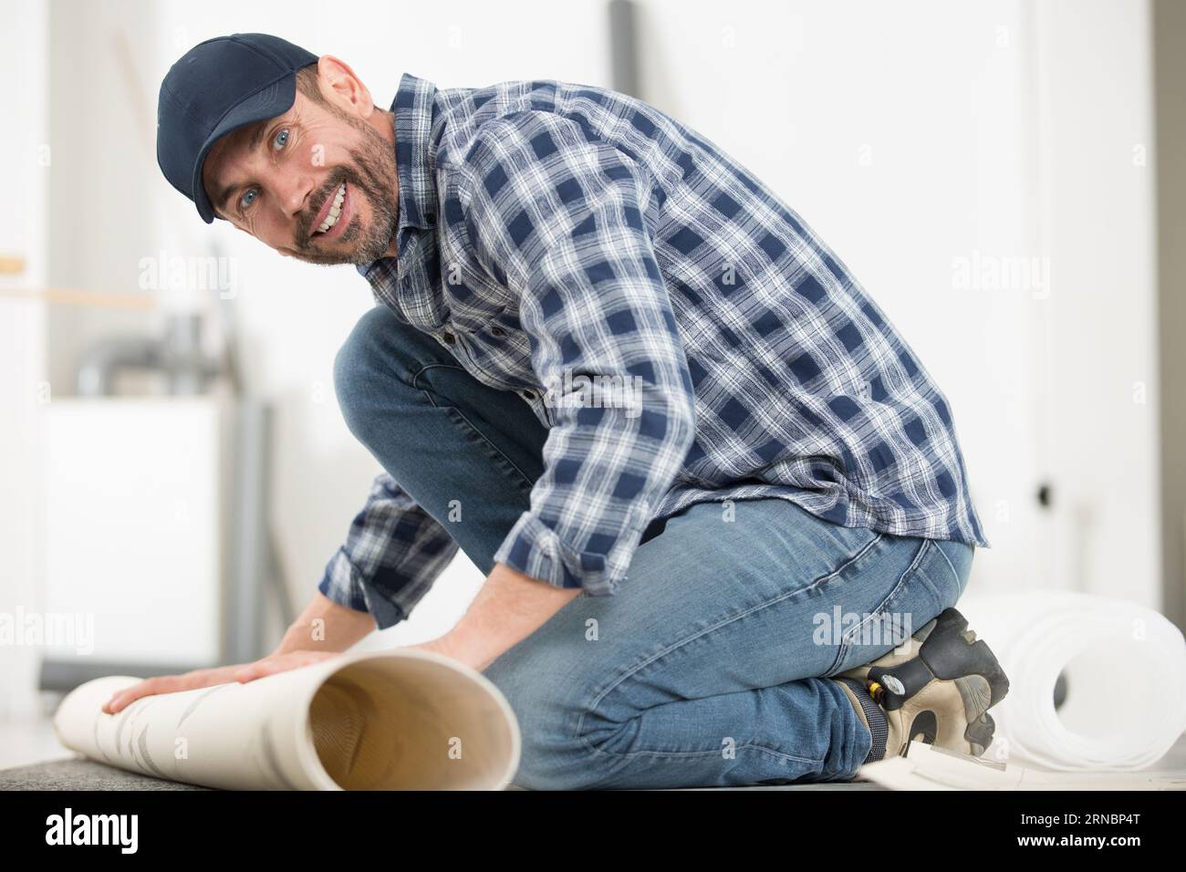 male handyman rolling carpet on floor at home Stock Photo - Alamy