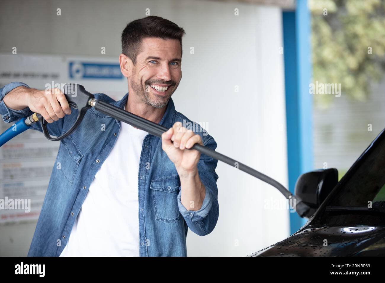 man pressure washing his car Stock Photo - Alamy