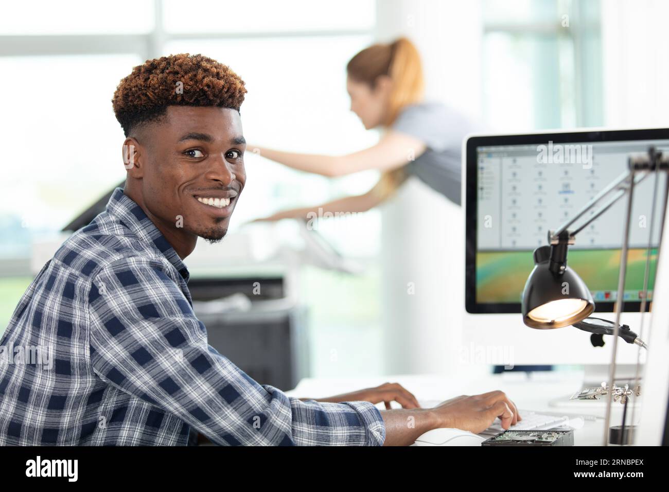 male student working at a desk Stock Photo - Alamy
