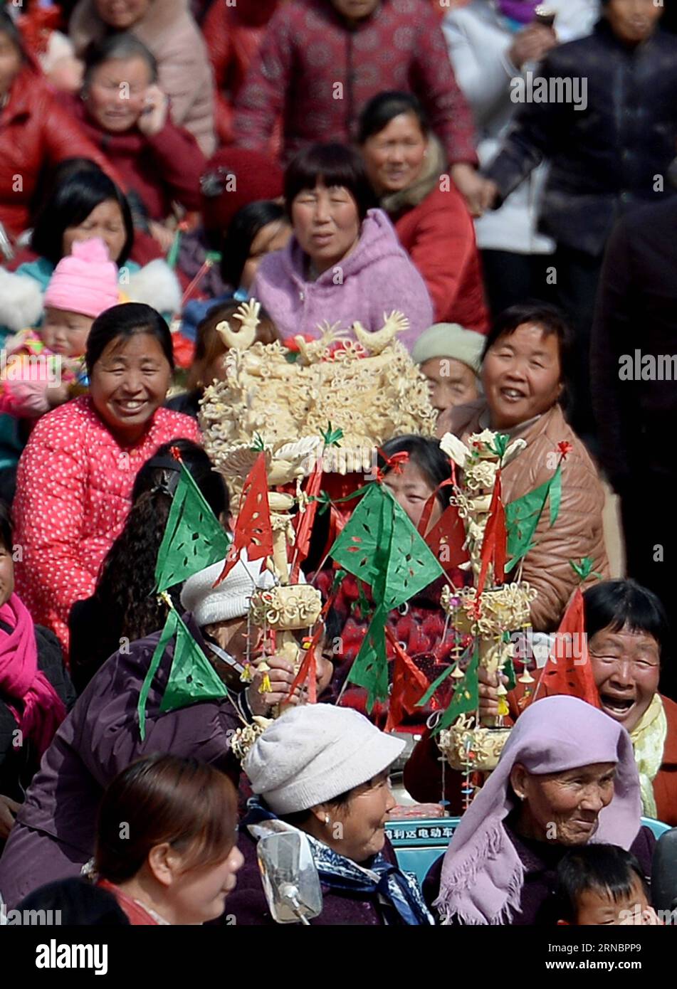 (160310) -- DALI, March 10, 2016 -- Villagers crowd the street with ...