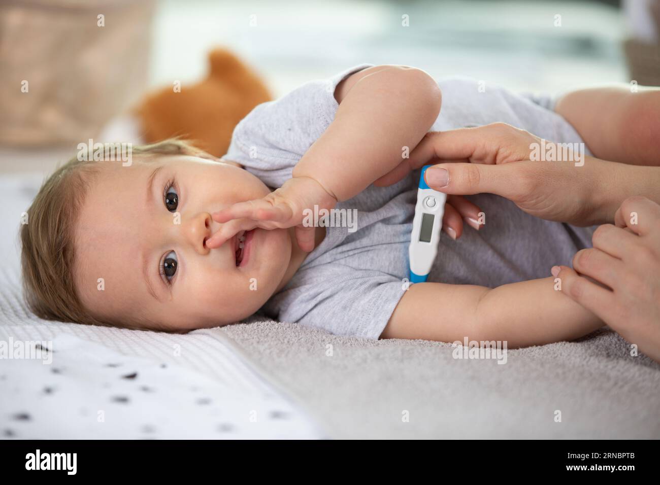 baby sick with measuring electric thermometer Stock Photo - Alamy