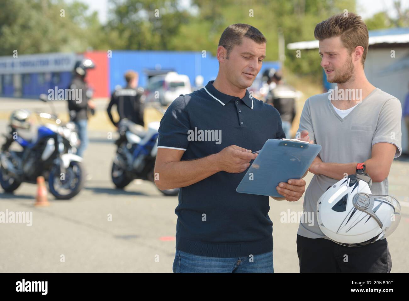 motorcycle driving instructor talking to candidate Stock Photo - Alamy