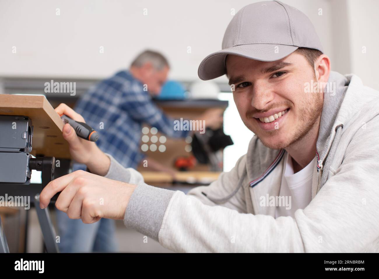happy apprentice working with wood on construction site Stock Photo - Alamy