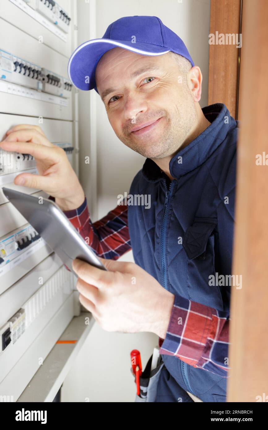 engineer switches on circuit breaker in electric switchboard close-up ...
