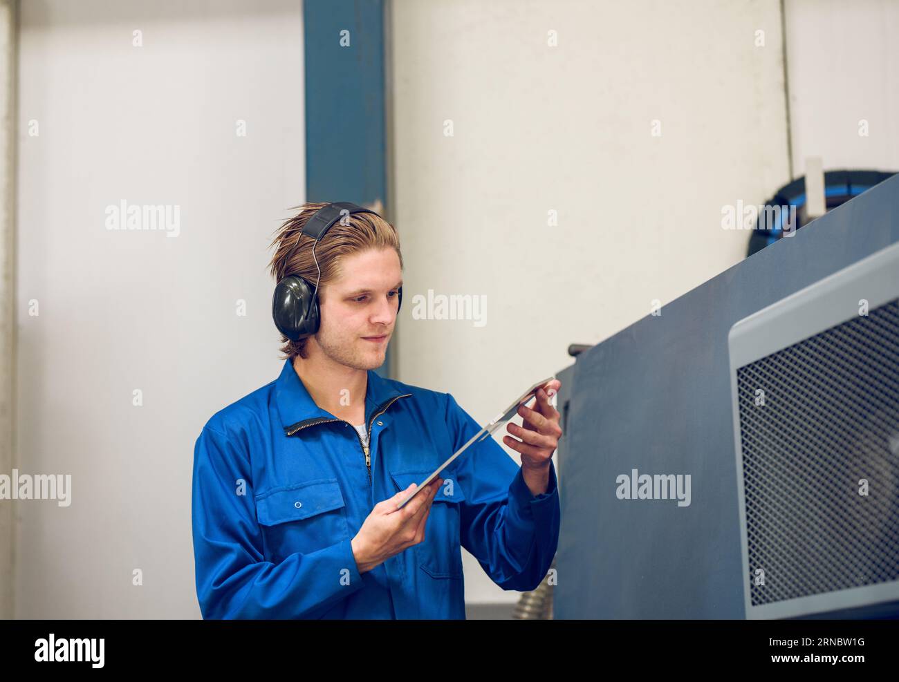 Man in headphones working on factory Stock Photo - Alamy