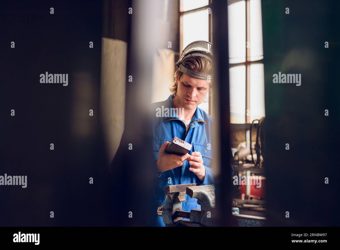 Serious man with helmet on factory Stock Photo - Alamy