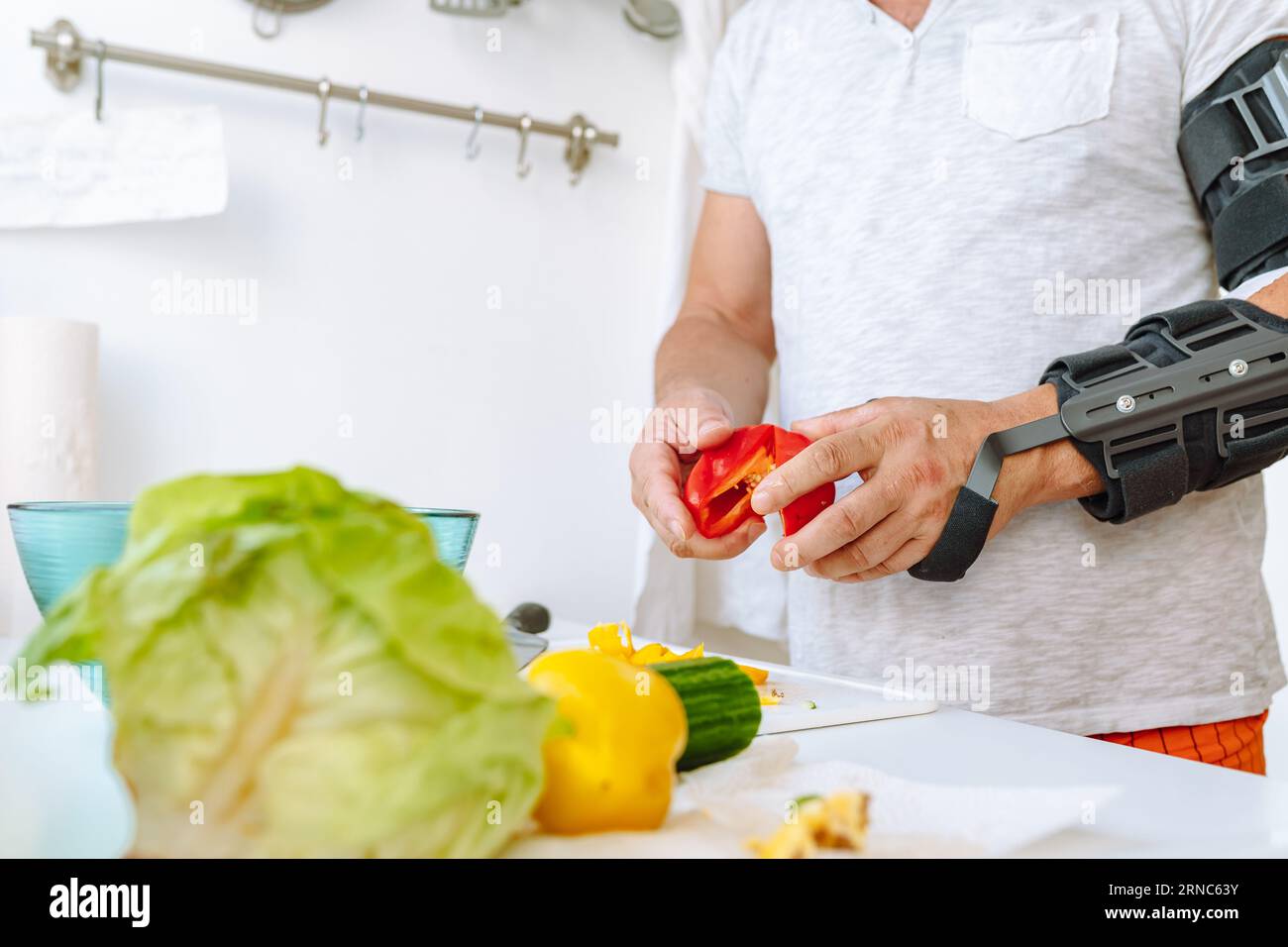 Man with injured hand making salad Stock Photo - Alamy