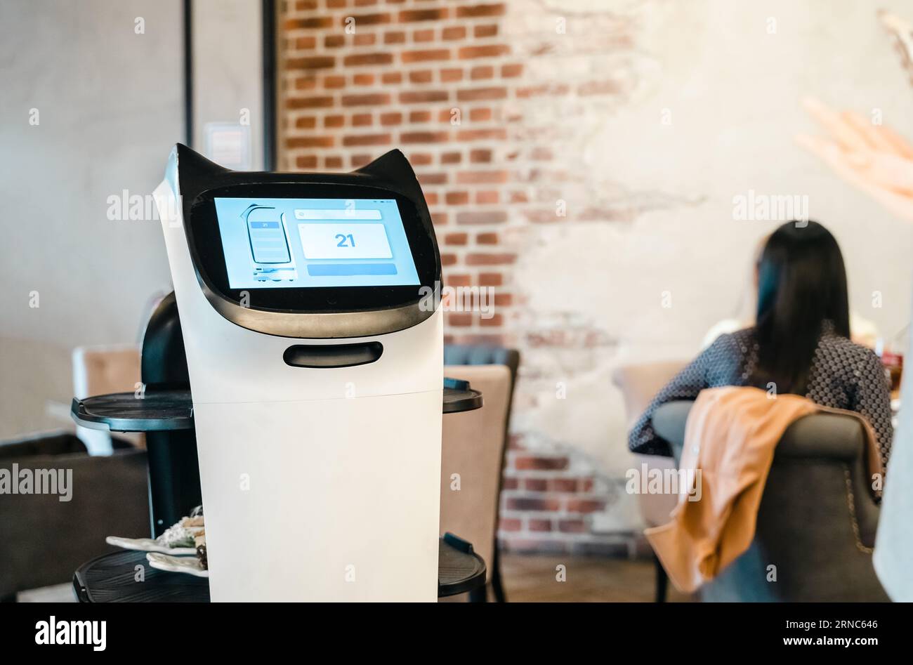 Robot waiter serve food at modern restaurant table.Offering innovation ...