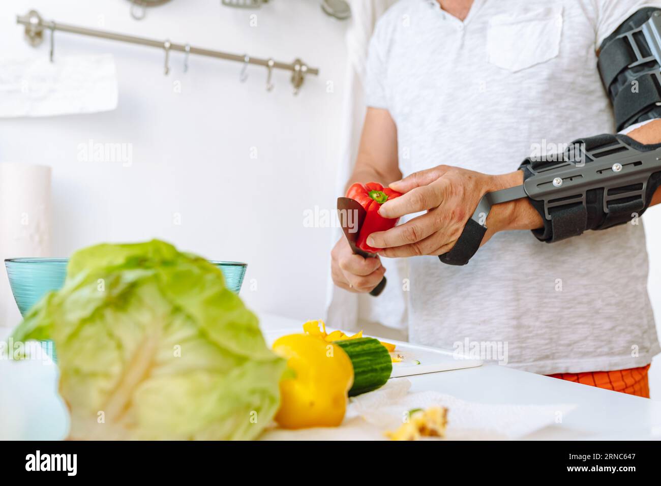 Man with injured hand making salad Stock Photo - Alamy
