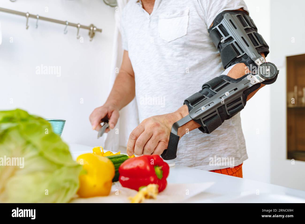 Man with injured hand making salad Stock Photo - Alamy