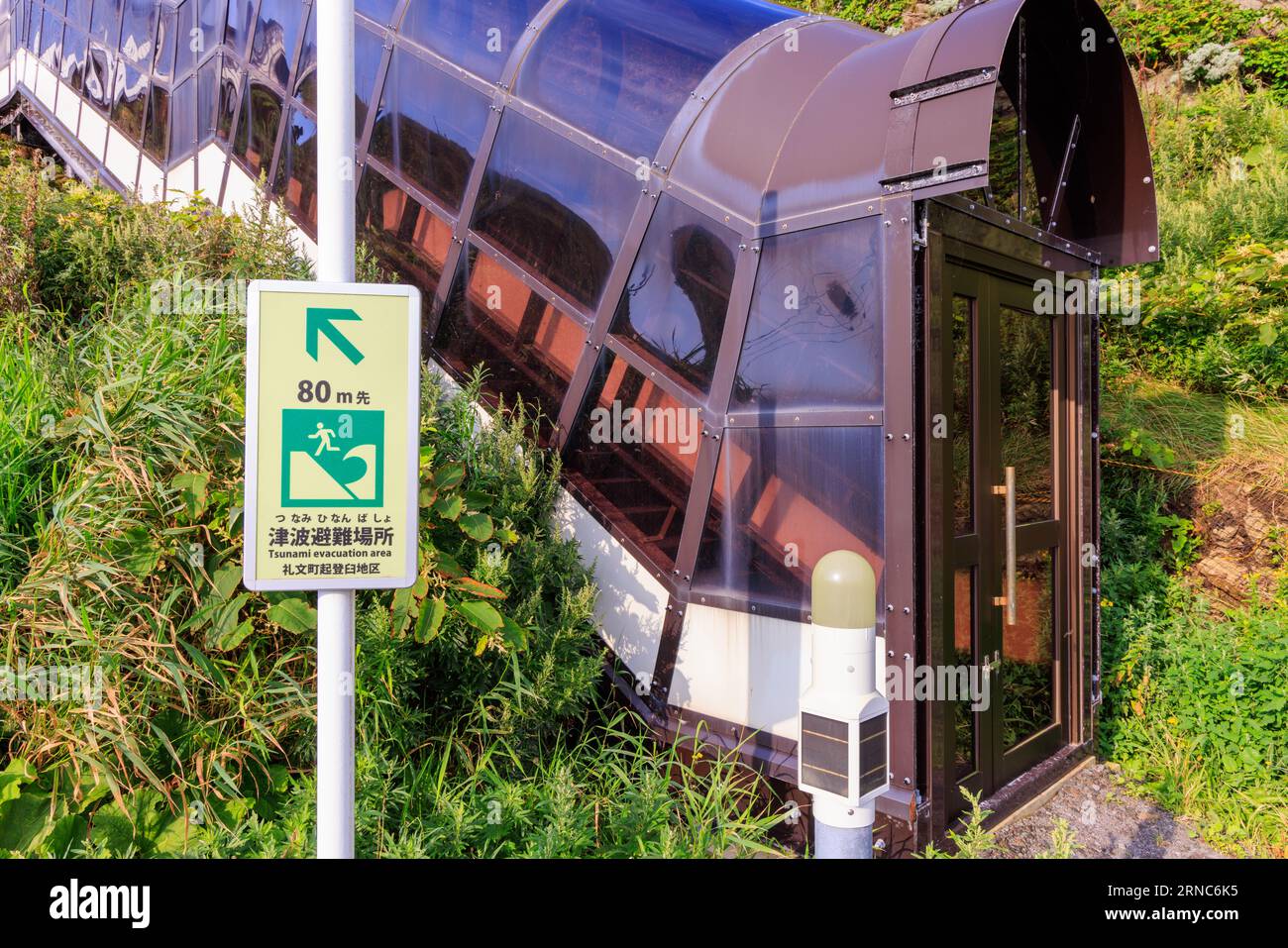 Sign by covered stairs along tsunami escape route on coast Stock Photo ...