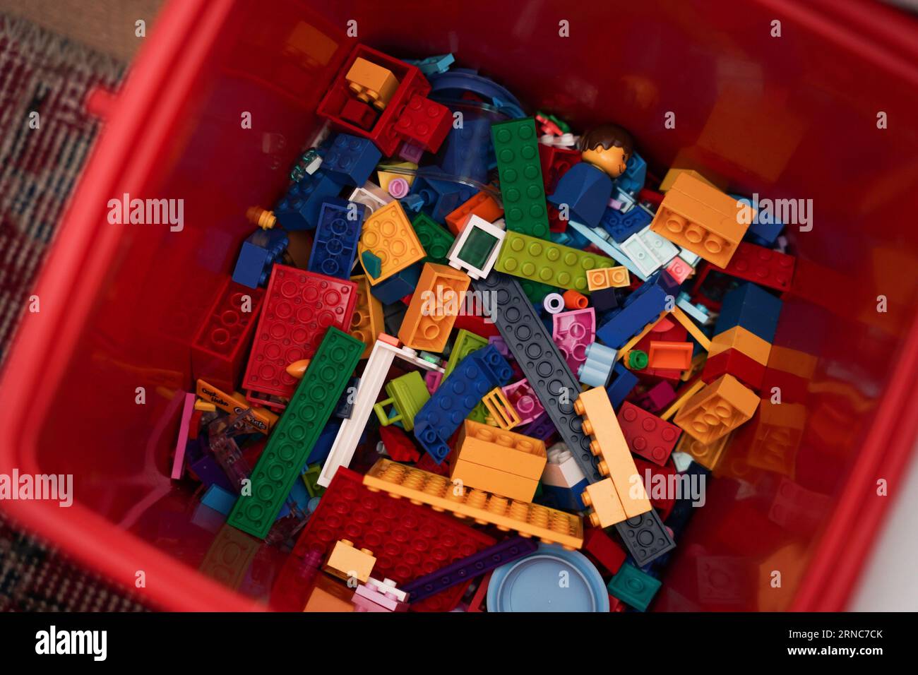 A collection of lego toys random picked up on red container Stock Photo ...