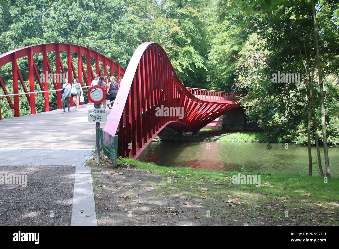 red coloured curved bridge over waterway Stock Photo - Alamy