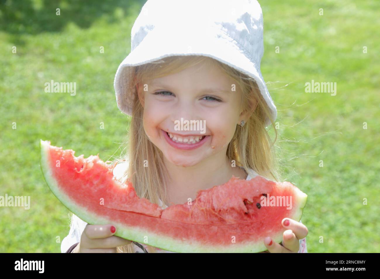 Happy little girl with big watermelon slice. Cild eating fruit. Outdoor ...