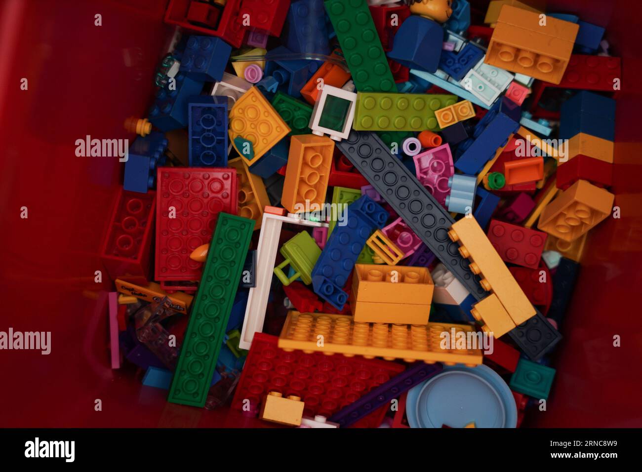 A collection of lego toys random picked up on red container Stock Photo ...