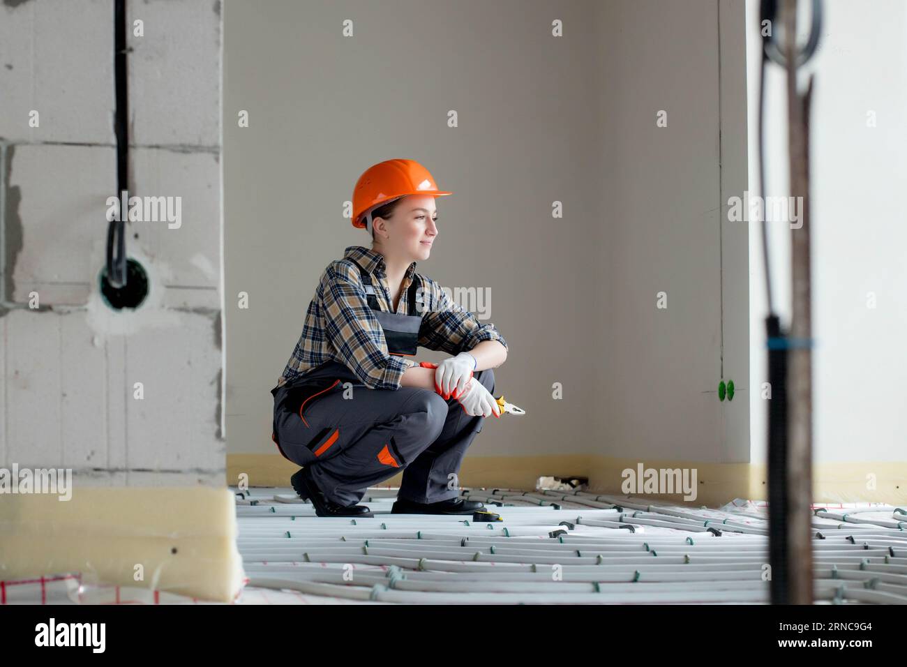 Portrait of woman worker which is installing underfloor heating system ...