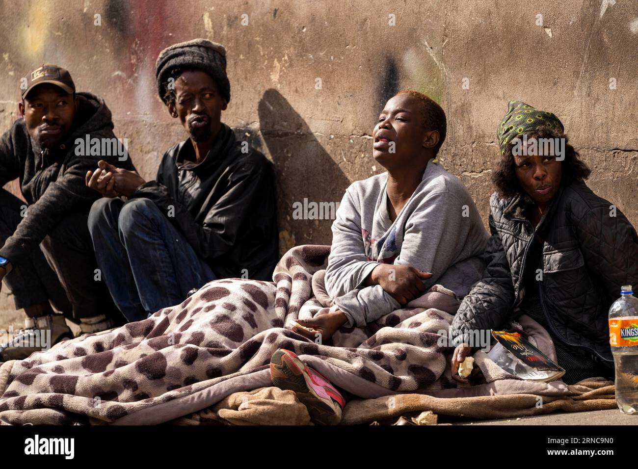 Homeless people sit near the scene of one of South Africa's deadliest ...