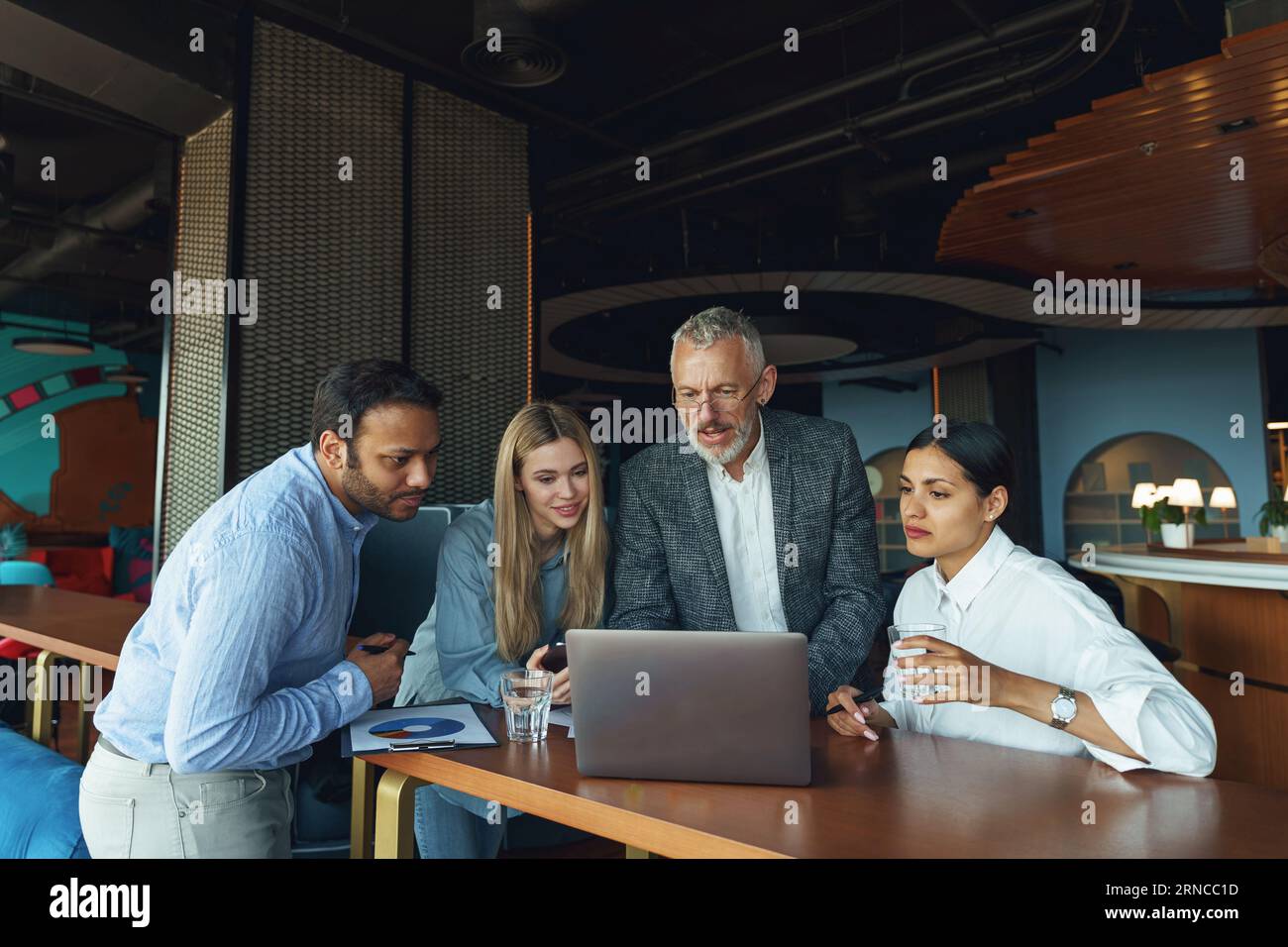Group of people discussing daily plans in the office using laptop ...