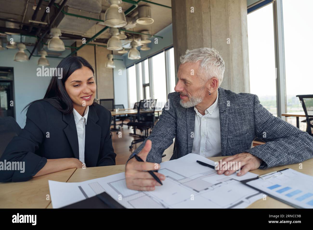 Two business colleagues talking in meeting room during work on project ...