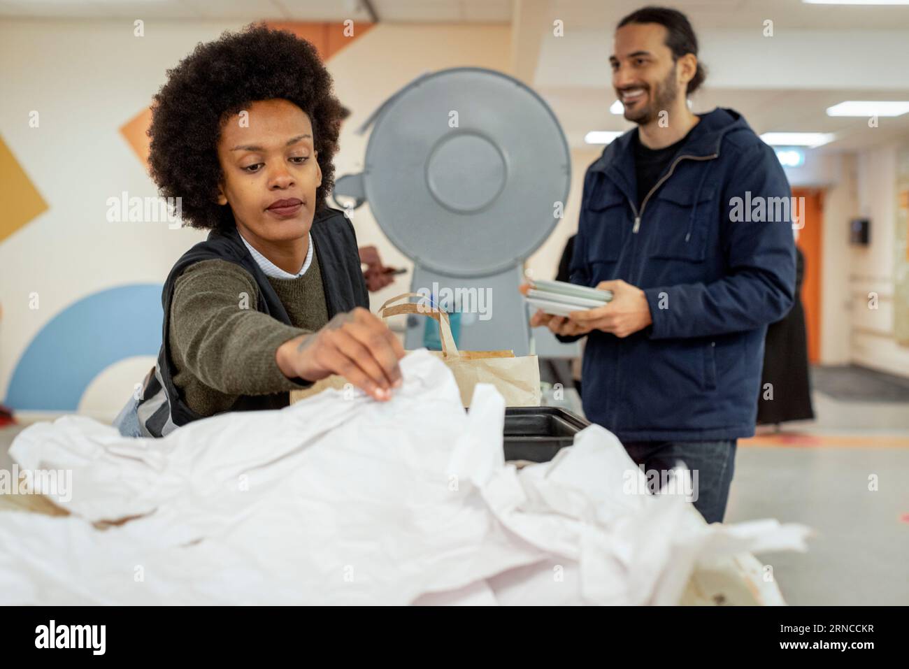 Female worker reaching at papers while working at recycling center ...