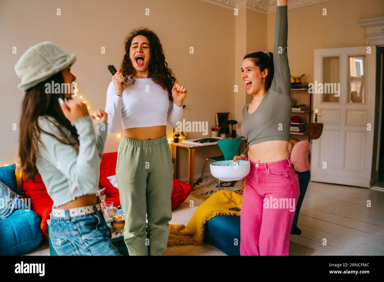 Young women shouting and cheering while watching TV at home Stock Photo ...