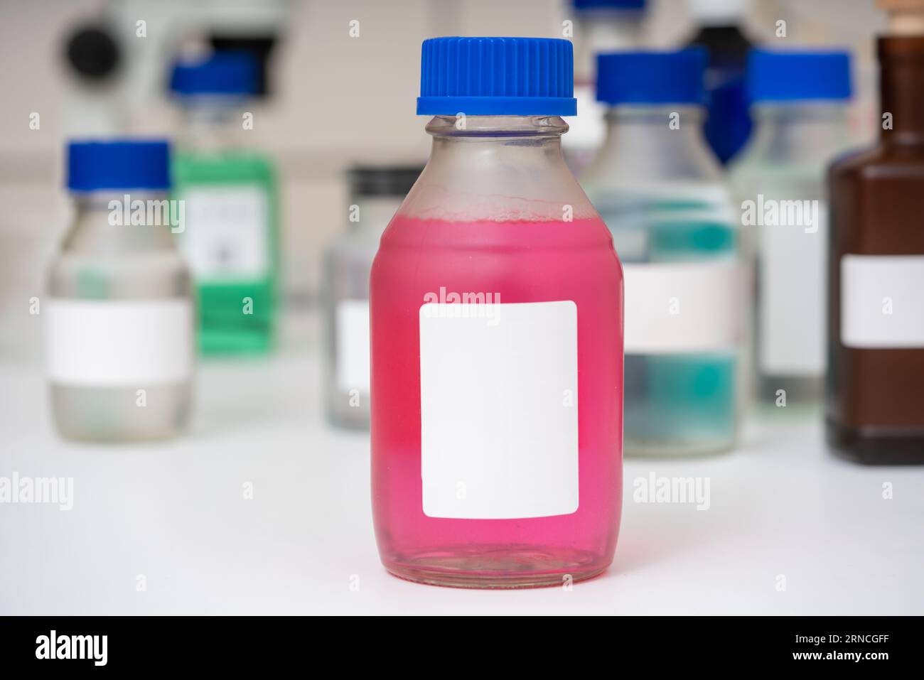 glass laboratory bottle with red liquid and blank label Stock Photo - Alamy