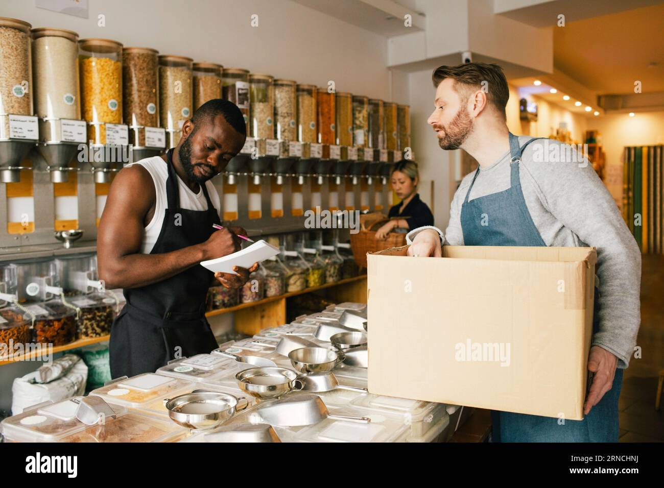 Multiracial male colleagues working in food store Stock Photo - Alamy