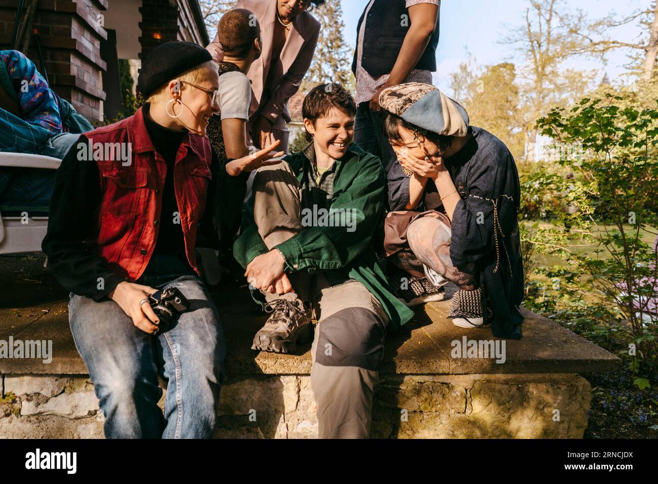 Happy friends of LGBTQ community enjoying together while sitting on ...