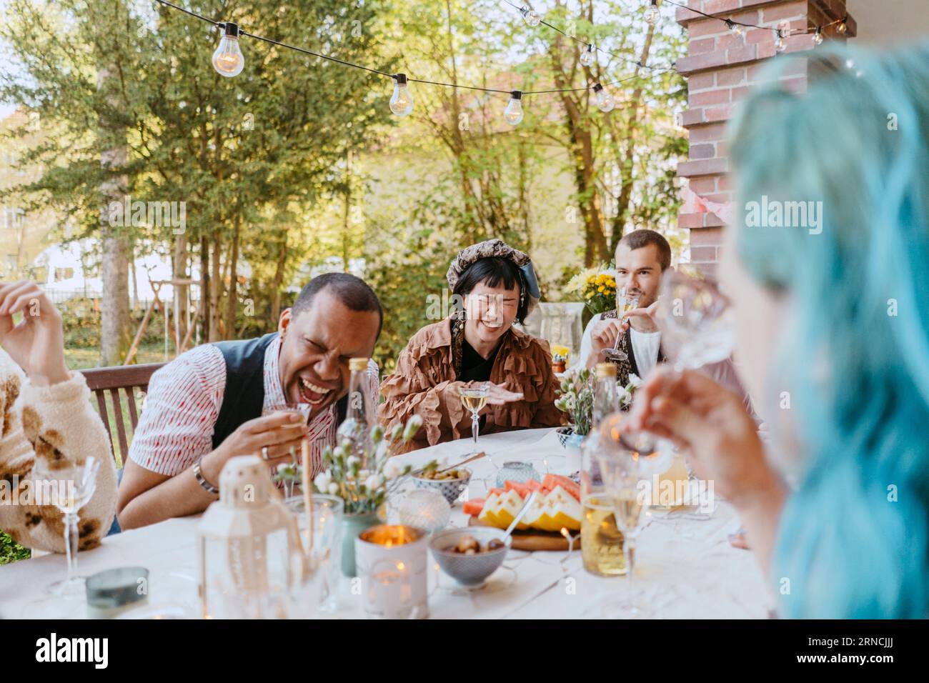 Friends of LGBTQ community enjoying drinks during dinner party in back ...
