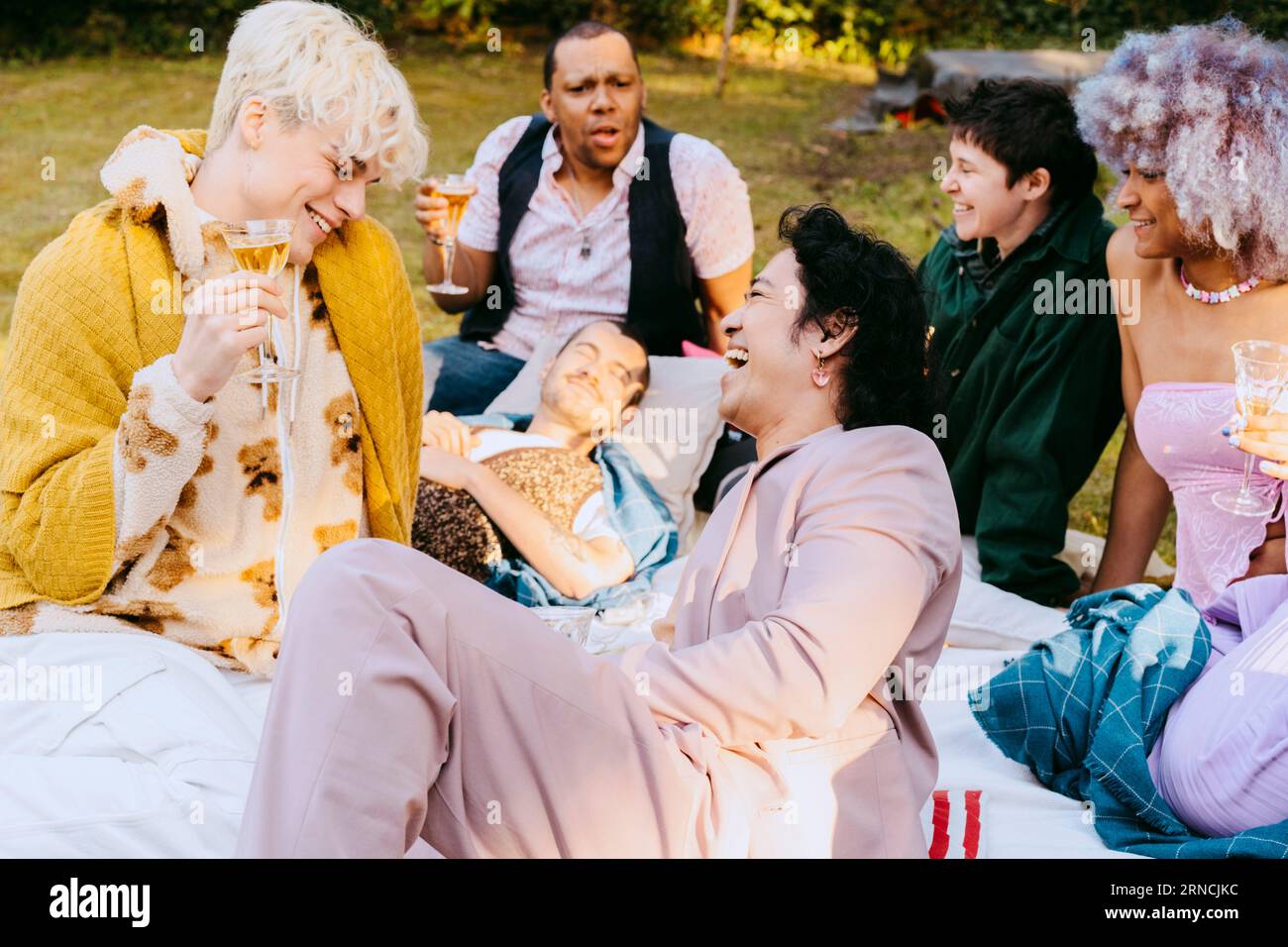 Happy friends from LGBTQ community laughing together during dinner ...