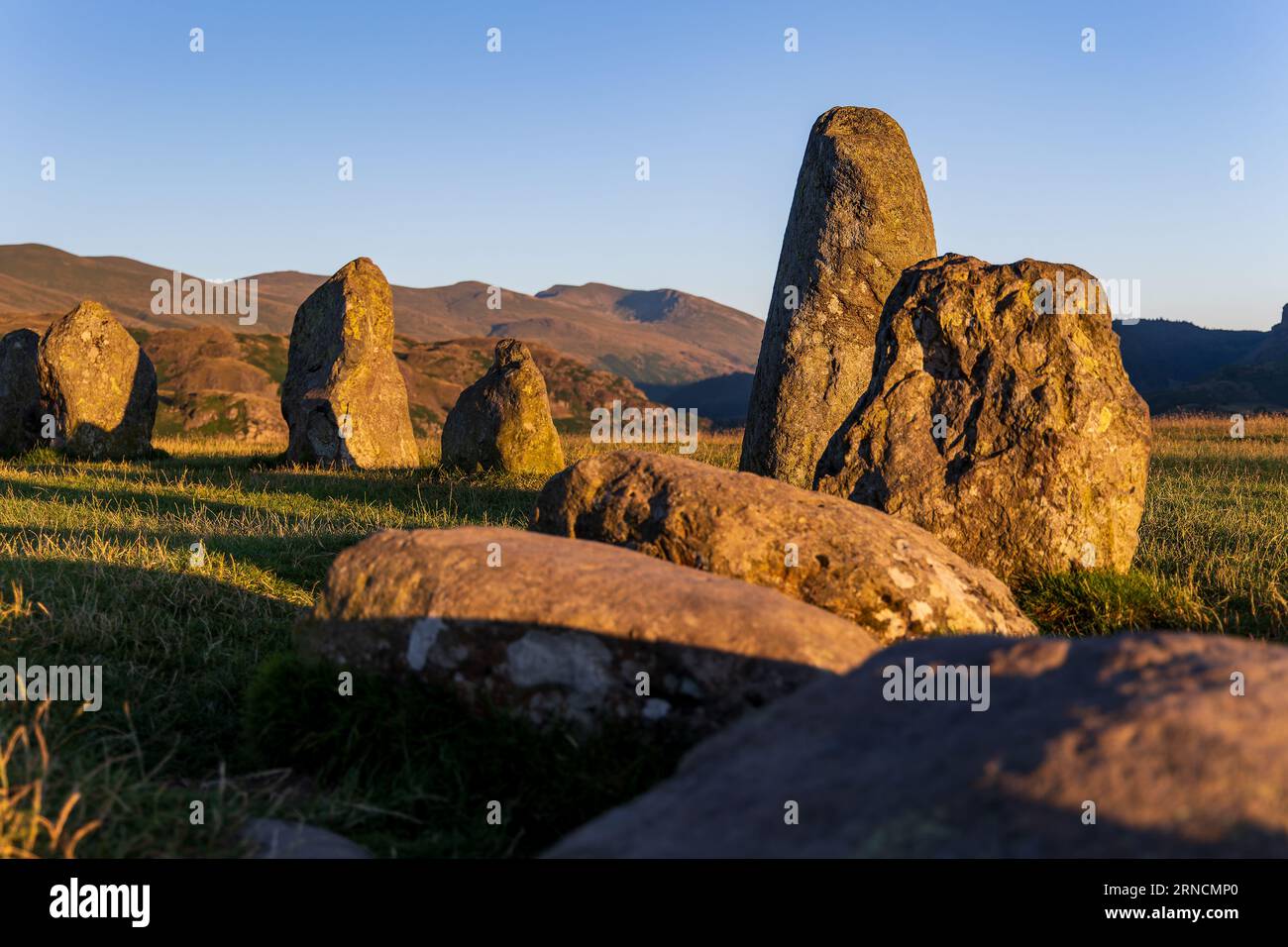 An ancient standing stone circle on high ground surrounded by mountains ...