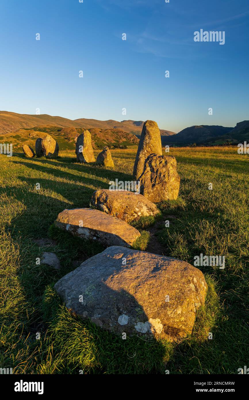 An ancient standing stone circle on high ground surrounded by mountains ...