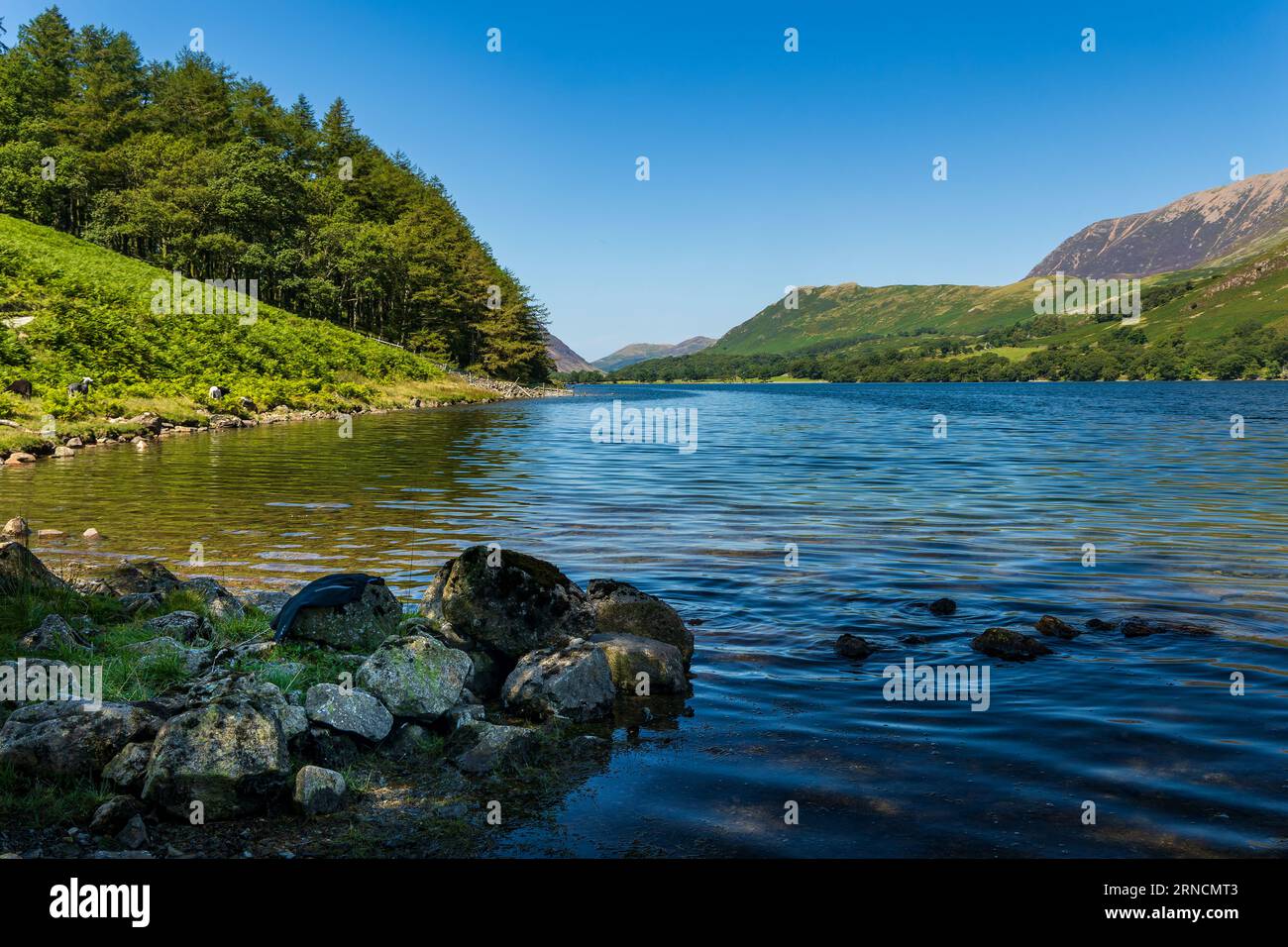 A beautiful, calm lake surrounded by high mountains in summer ...