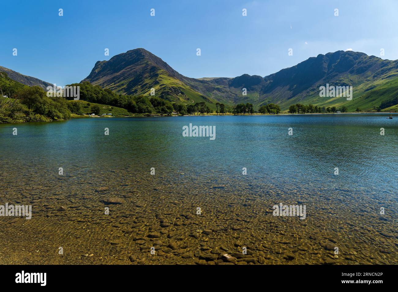 A beautiful, calm lake surrounded by high mountains in summer ...