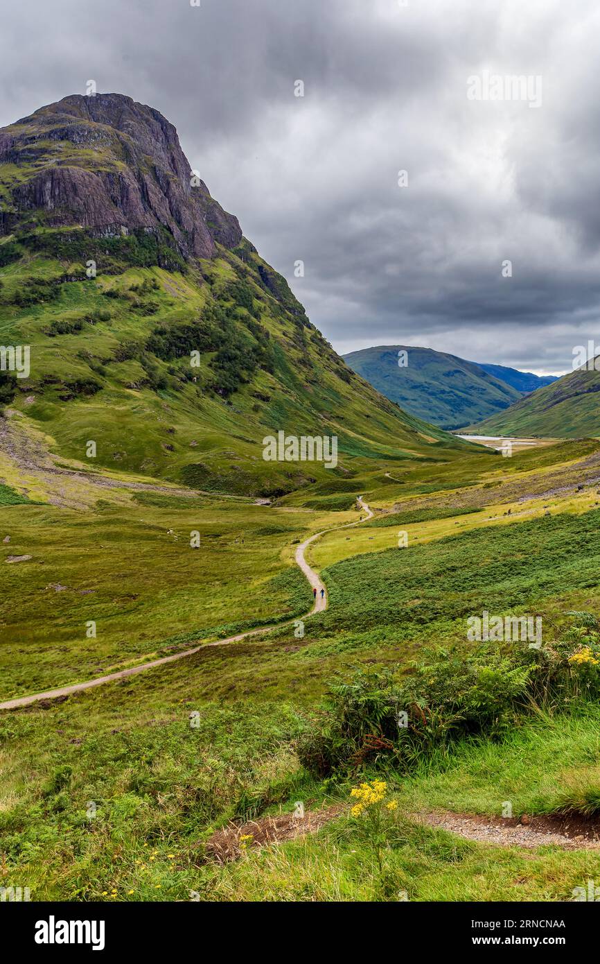 Hiking trail leading into a valley surrounded by steep mountains and a ...