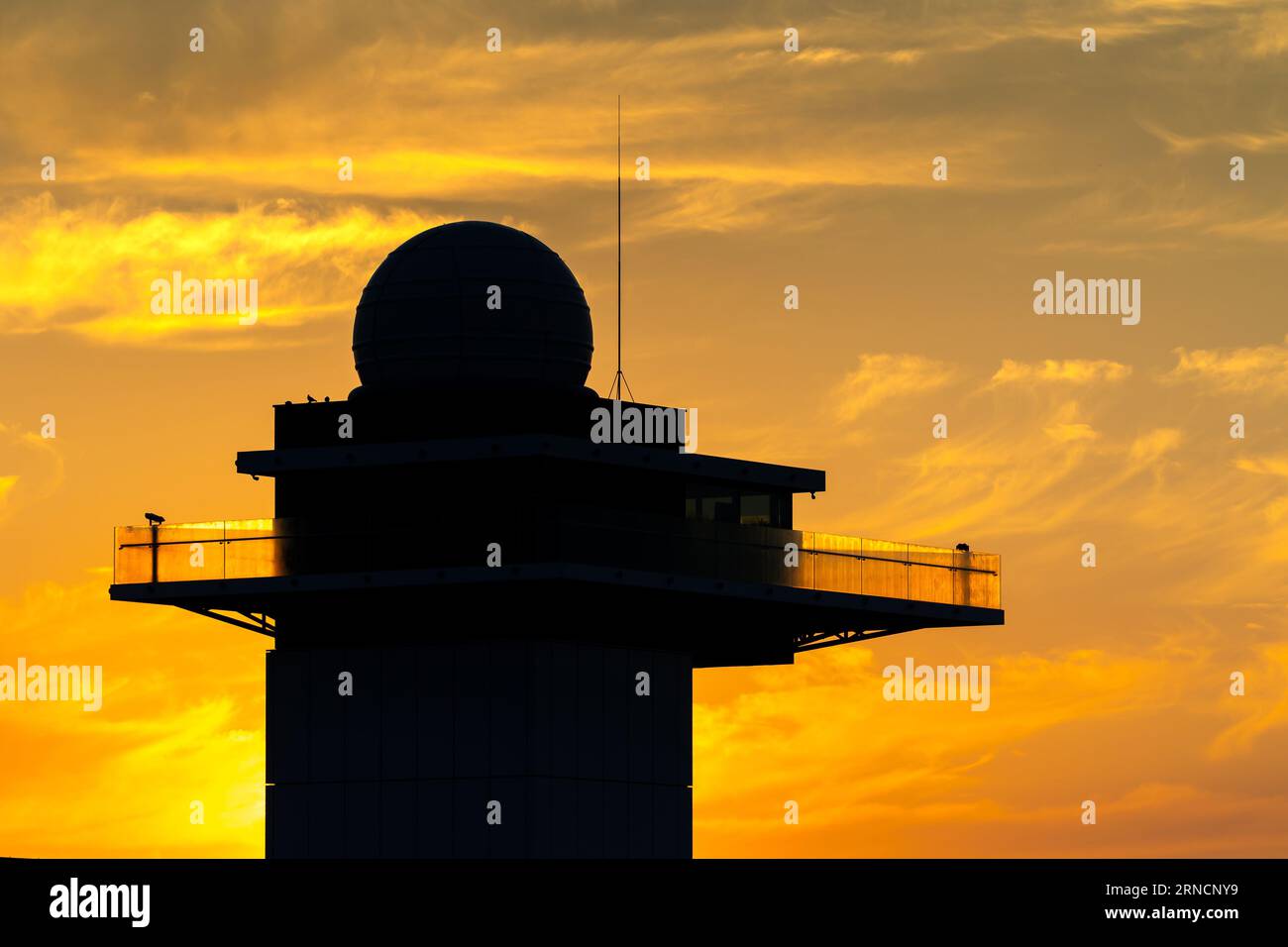 The dome of the astronomical observatory against the orange, sunset sky ...