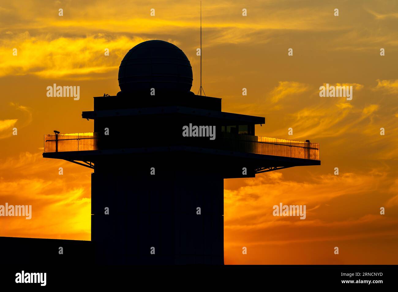 The dome of the astronomical observatory against the orange, sunset sky ...
