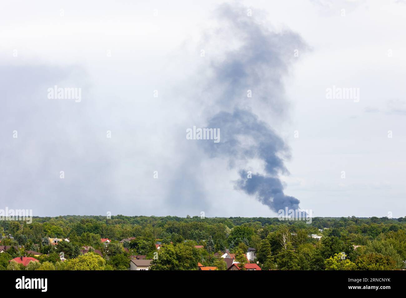 Black smoke from a fire rising over the horizon. Air pollution by ...