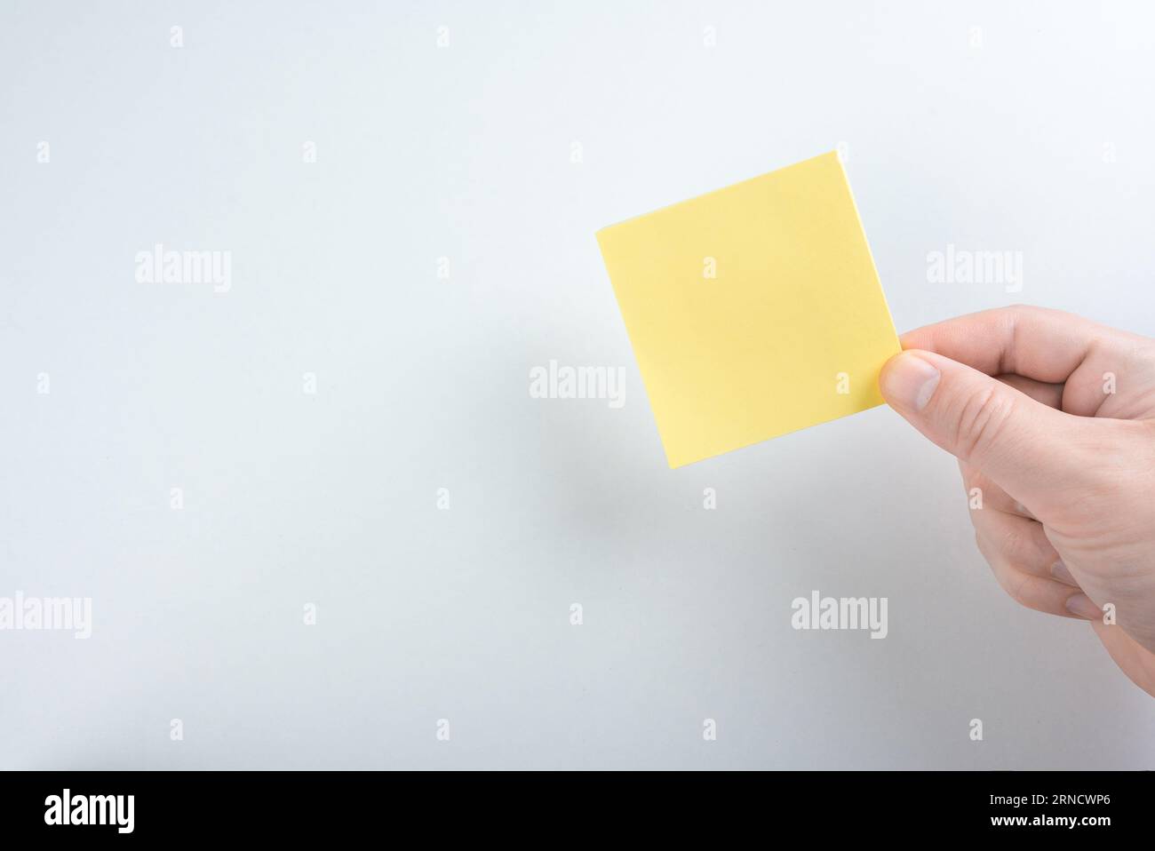 Blank sheet for notes. male hand holding note paper mockup for making ...