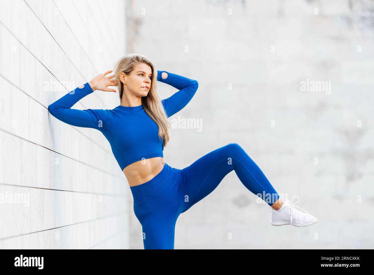 Fitness sport woman doing stretching exercise over gray wall ...