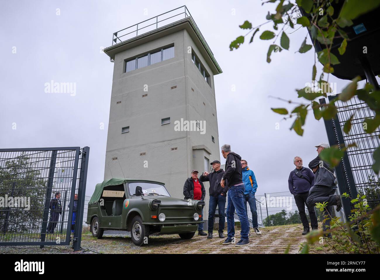 01 September 2023, Saxony, Heinersgrün: Guests stand around a Trabant ...